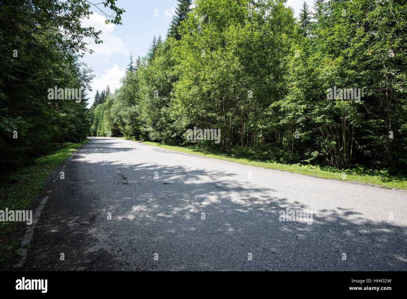 Winding country Road with clouds above and dry tarmac Stock Photo - Alamy