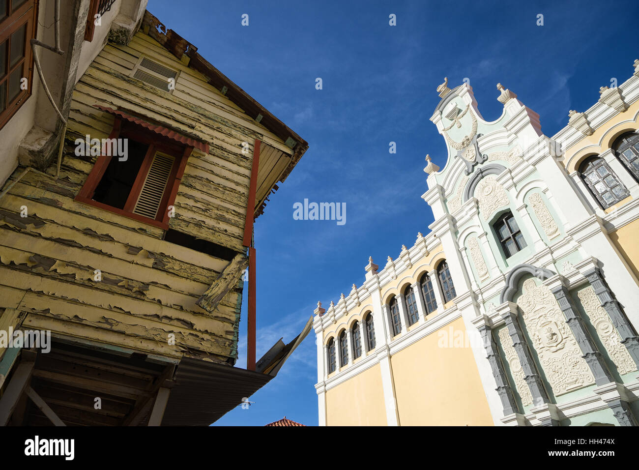 Colonial building facade newly renovated across a ruined wooden ...