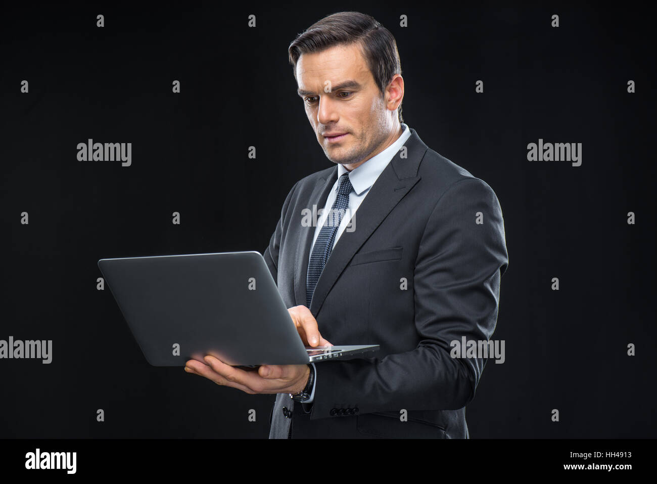 Young professional businessman using laptop on black Stock Photo - Alamy