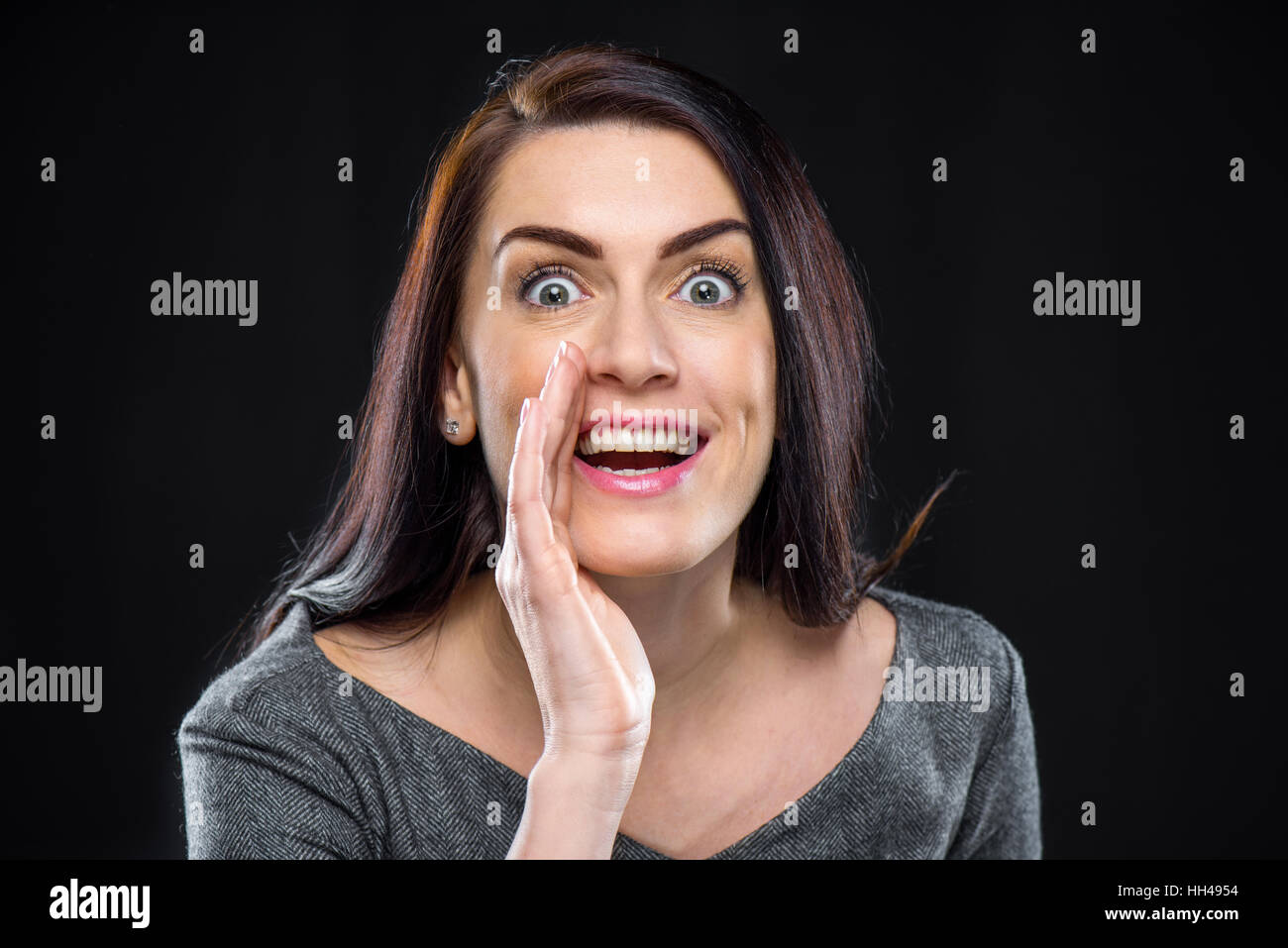 Exited woman telling secret holding her hand near mouth Stock Photo - Alamy
