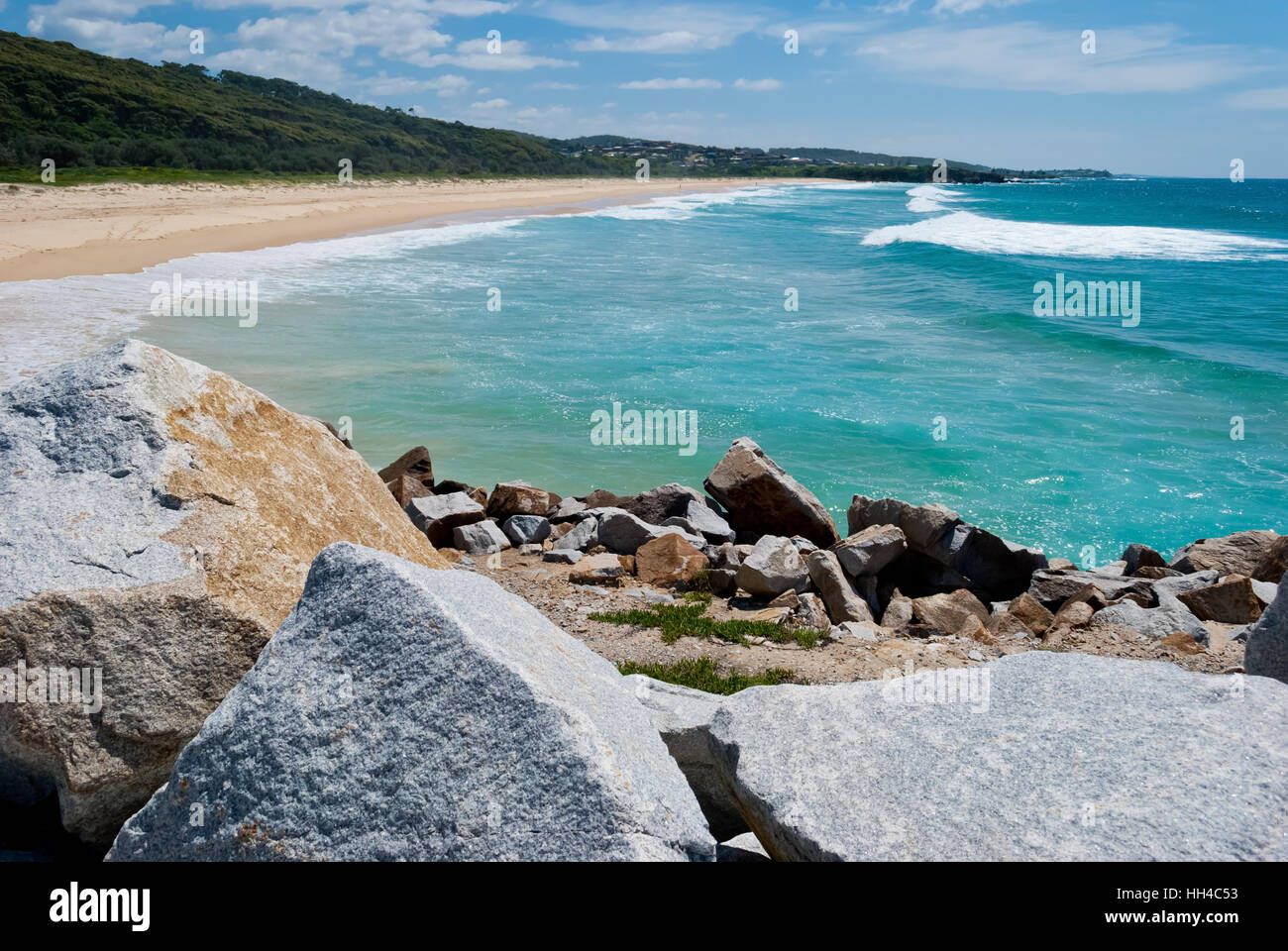 Sunny beach with rocks and crisp water Stock Photo - Alamy