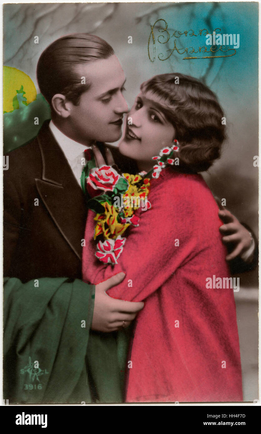 Kitsch New Years Greetings postcard featuring a young couple Stock ...