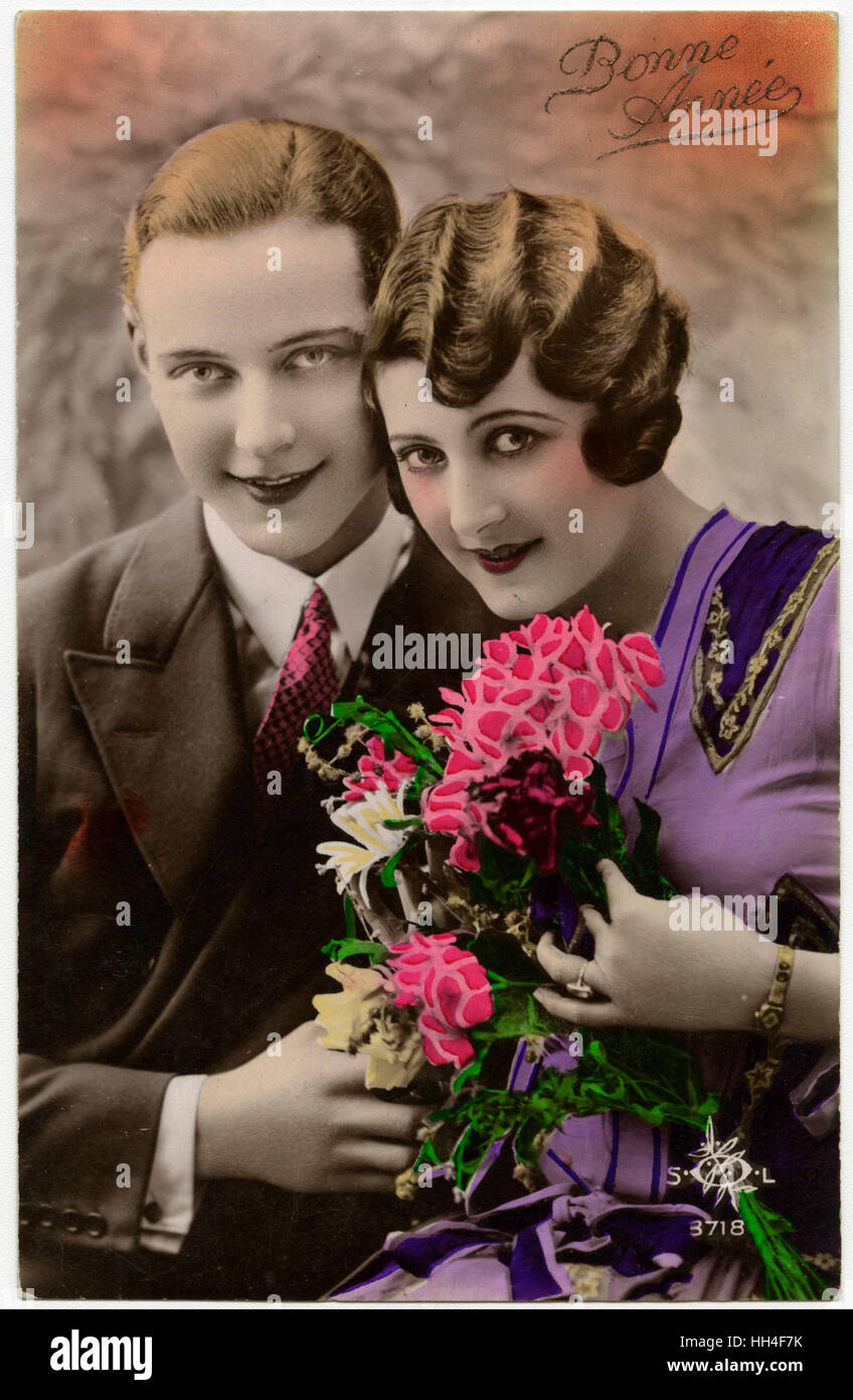 Kitsch New Years Greetings postcard featuring a young couple Stock ...