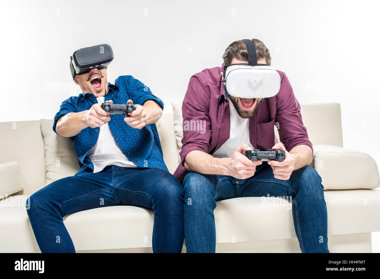 Excited male friends playing video games in virtual reality headsets ...