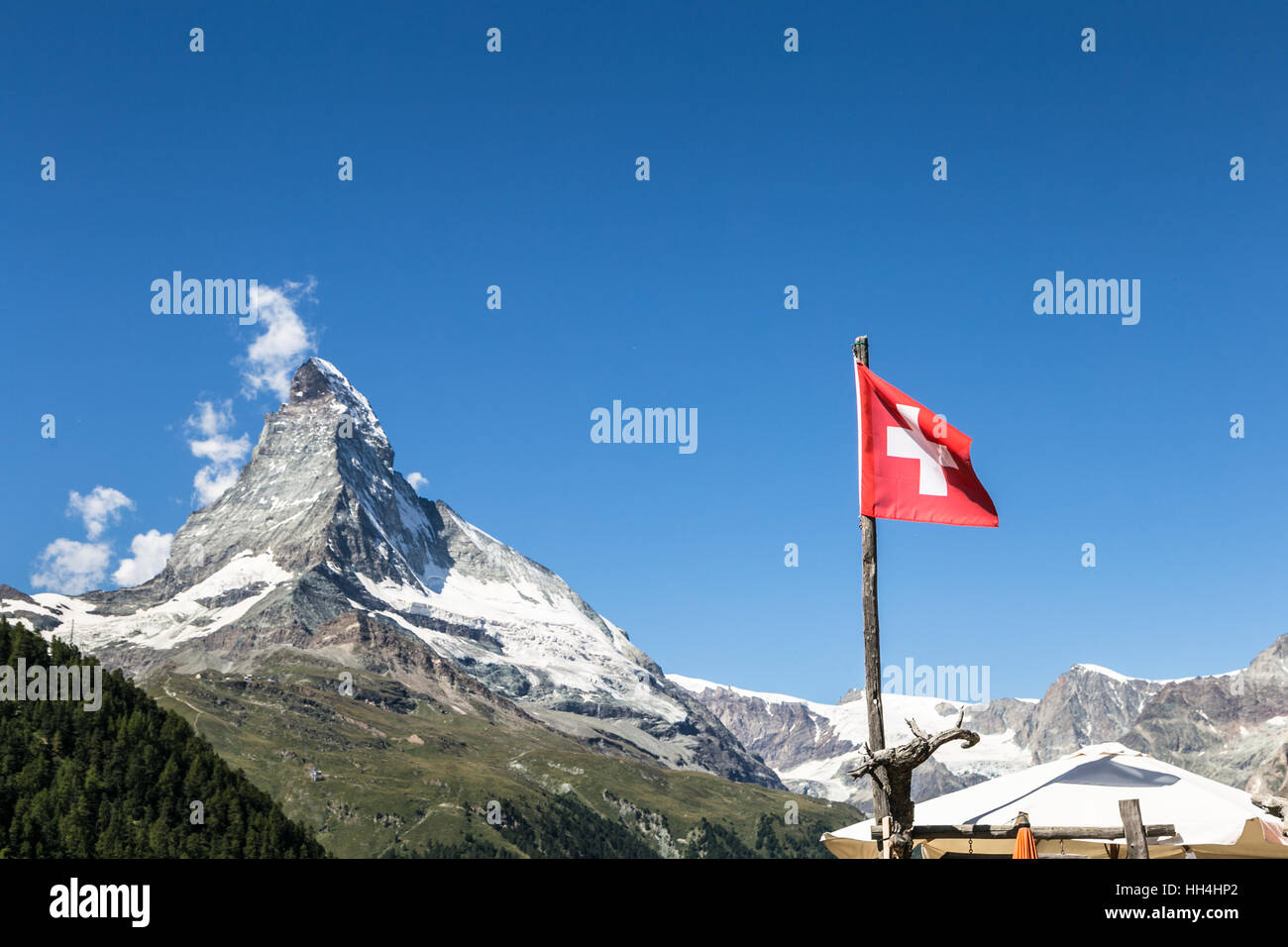 The Matterhorn and a Swiss flag above the famous village of Zermatt in ...