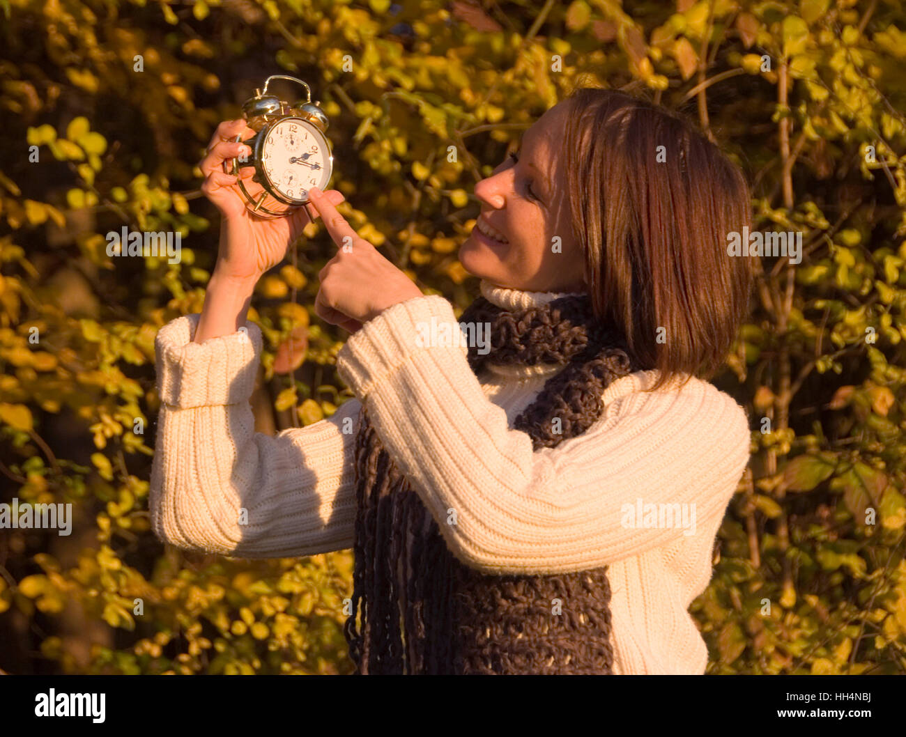 Woman with clock in autumn, wintertime Stock Photo - Alamy