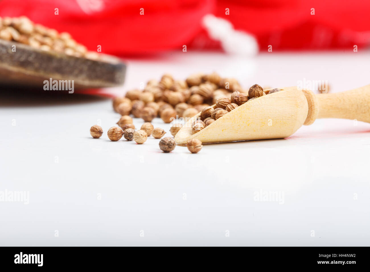 Aromatic color coriander seeds ingredient on white table with wooden ...