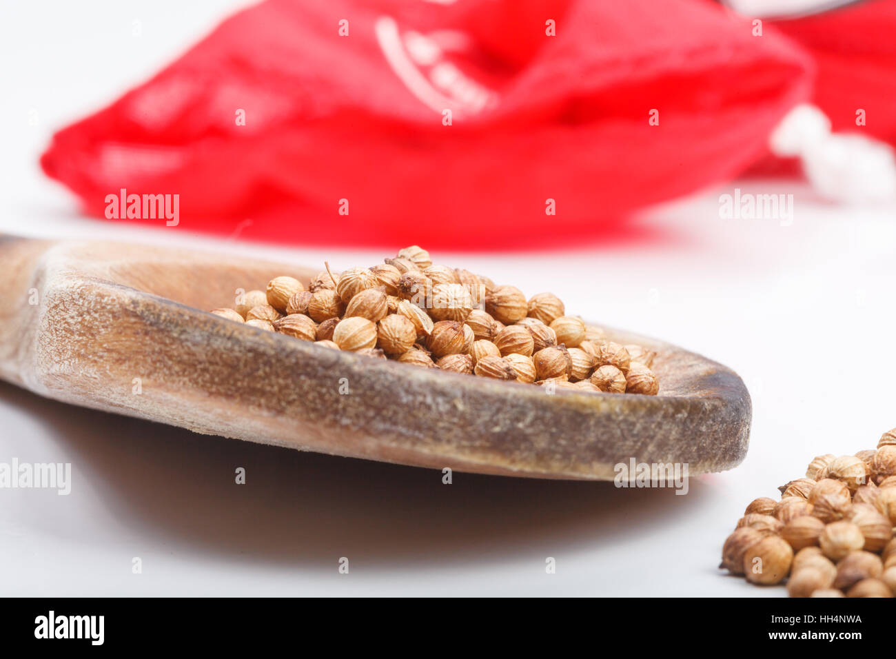 Aromatic color coriander seeds ingredient on white table with wooden ...