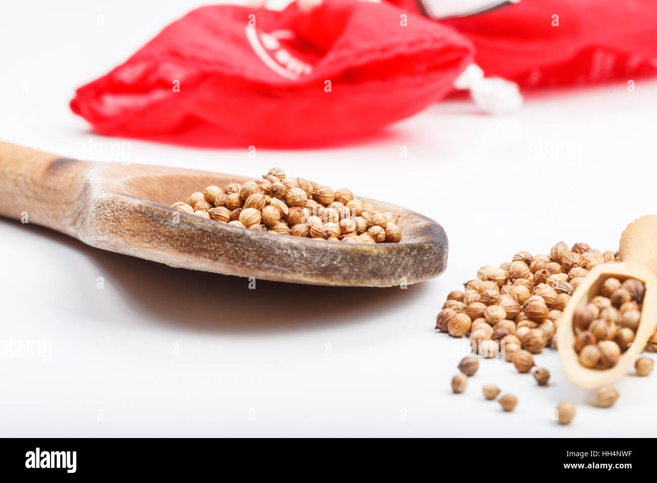 Aromatic color coriander seeds ingredient on white table with wooden ...