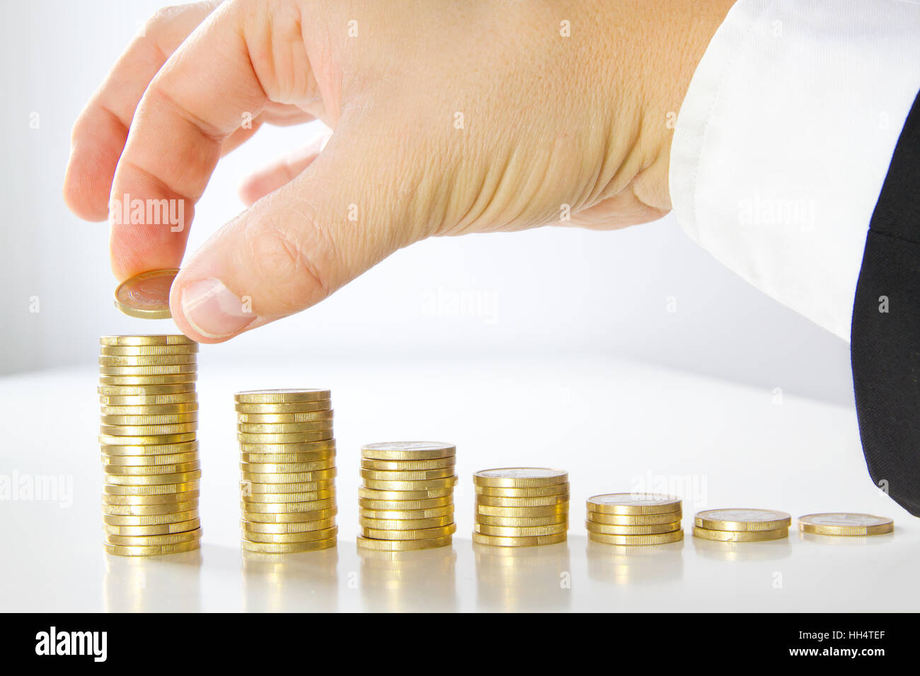 Businessman stacking coins Stock Photo - Alamy