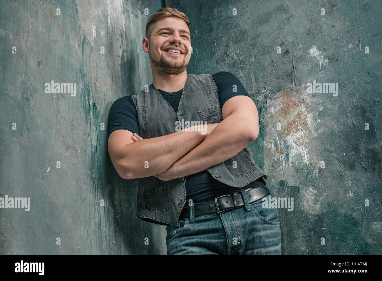 Portrait of smiling happy man standing on gray studio background Stock ...