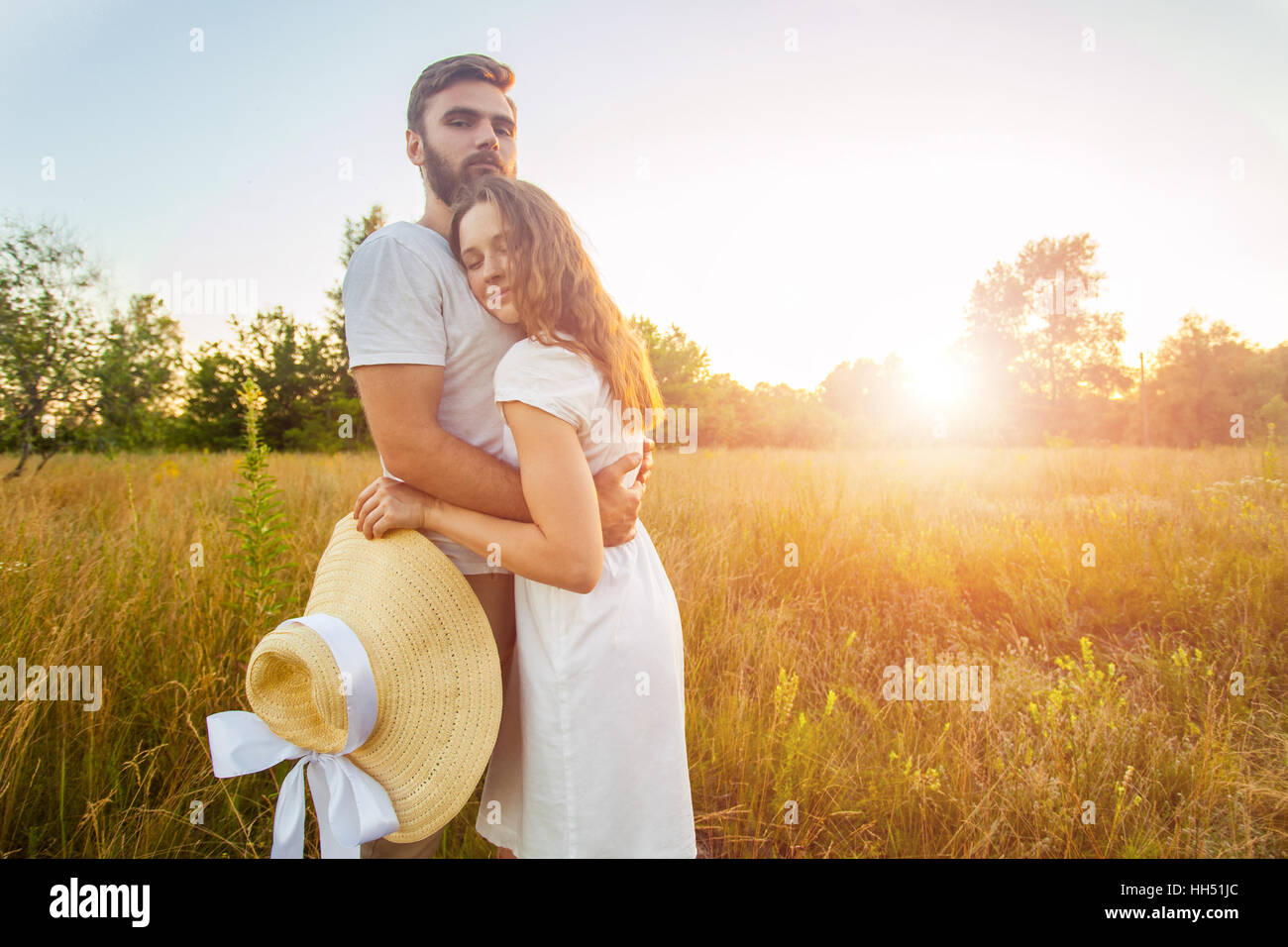 Happy beautiful couple hugs in park in the on the sunset Stock Photo ...