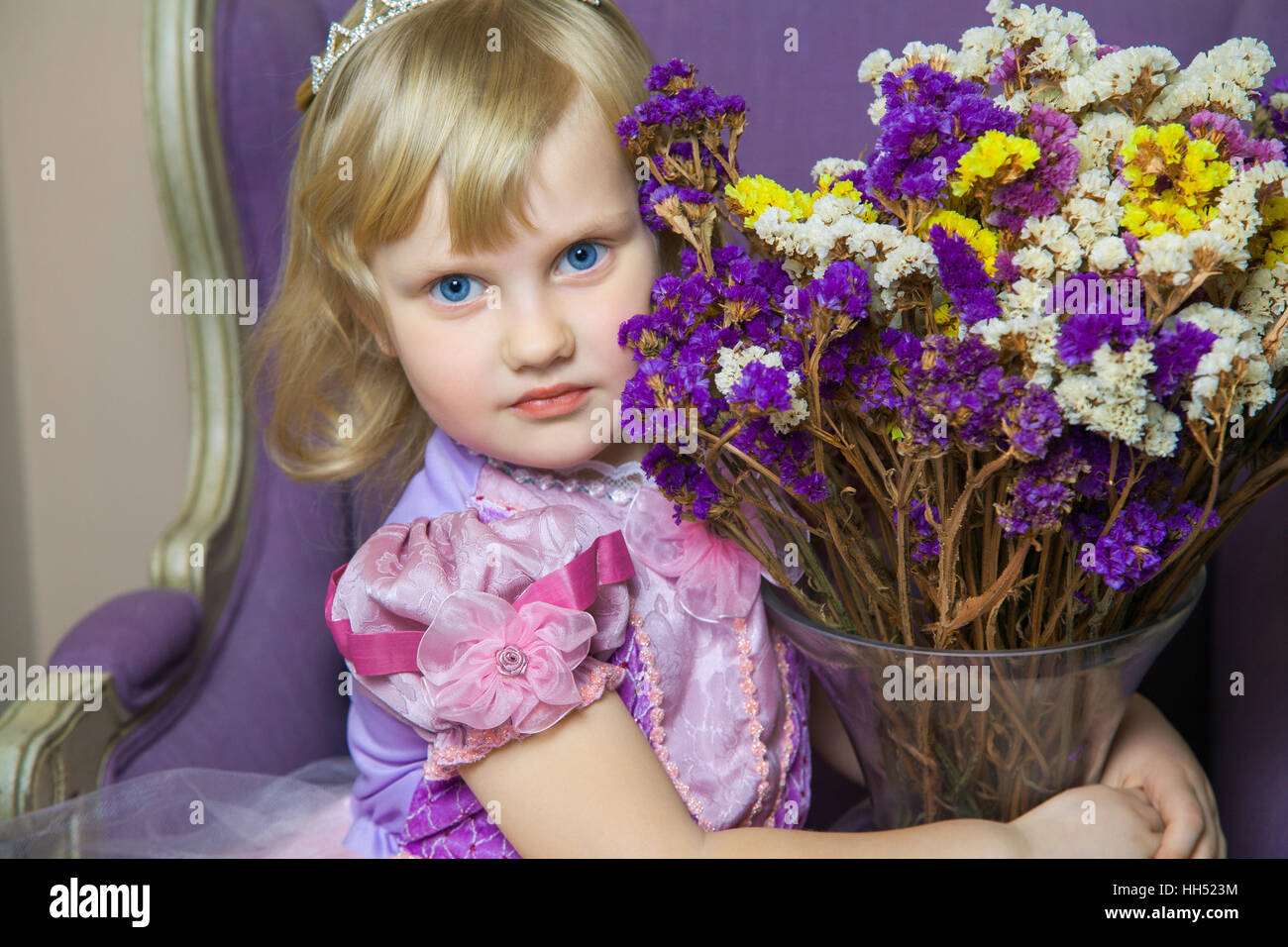 Little happy princess girl in pink dress and crown in her royal room ...