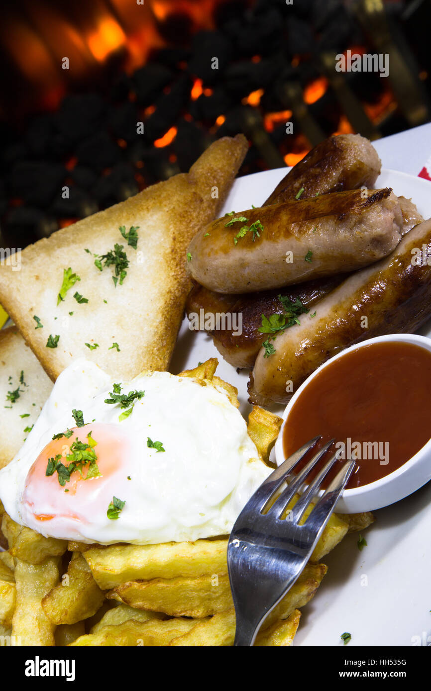 English pub dinner of Sausage, fried egg and chips/fries Stock Photo ...