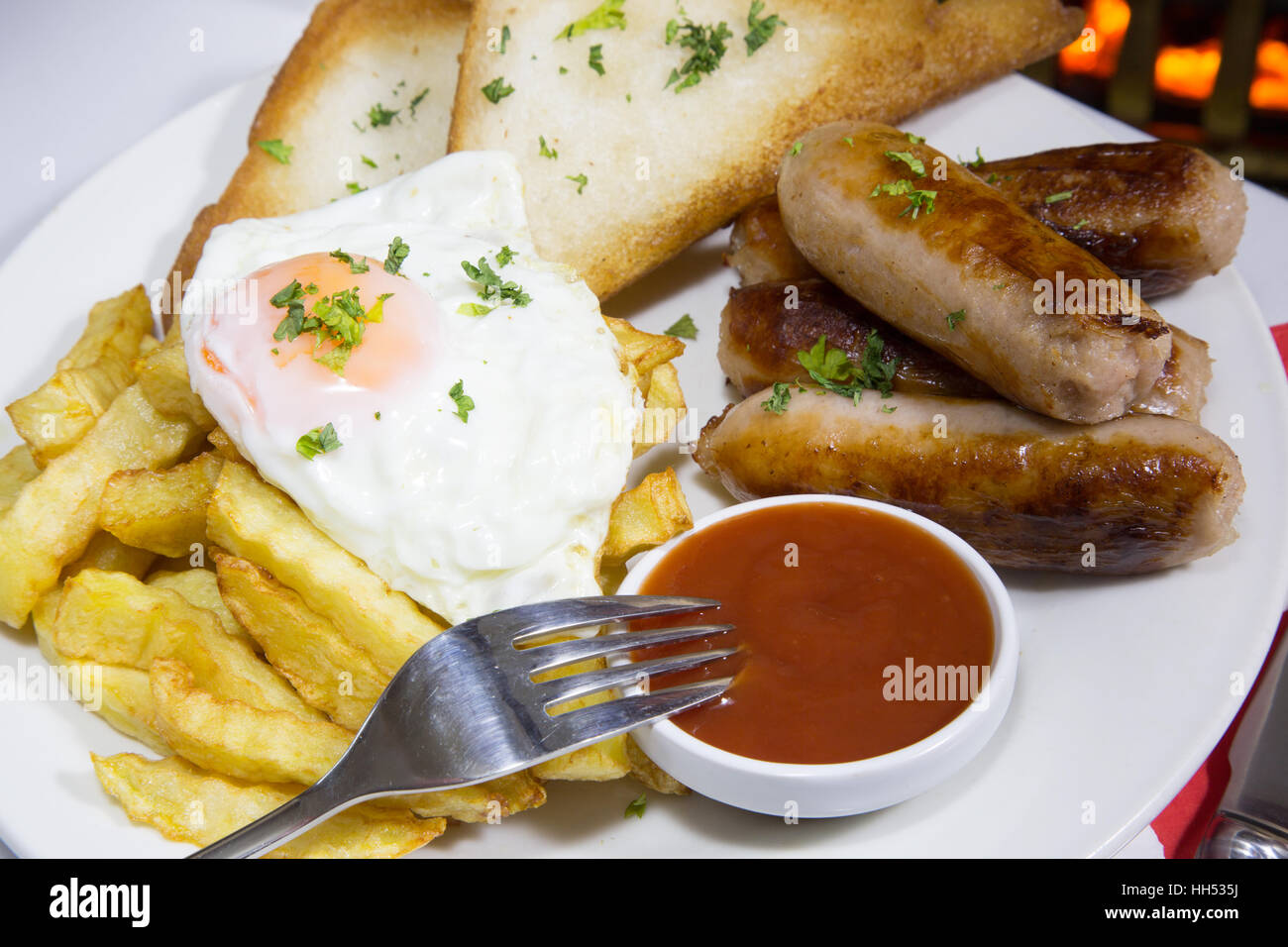 English pub dinner of Sausage, fried egg and chips/fries Stock Photo ...