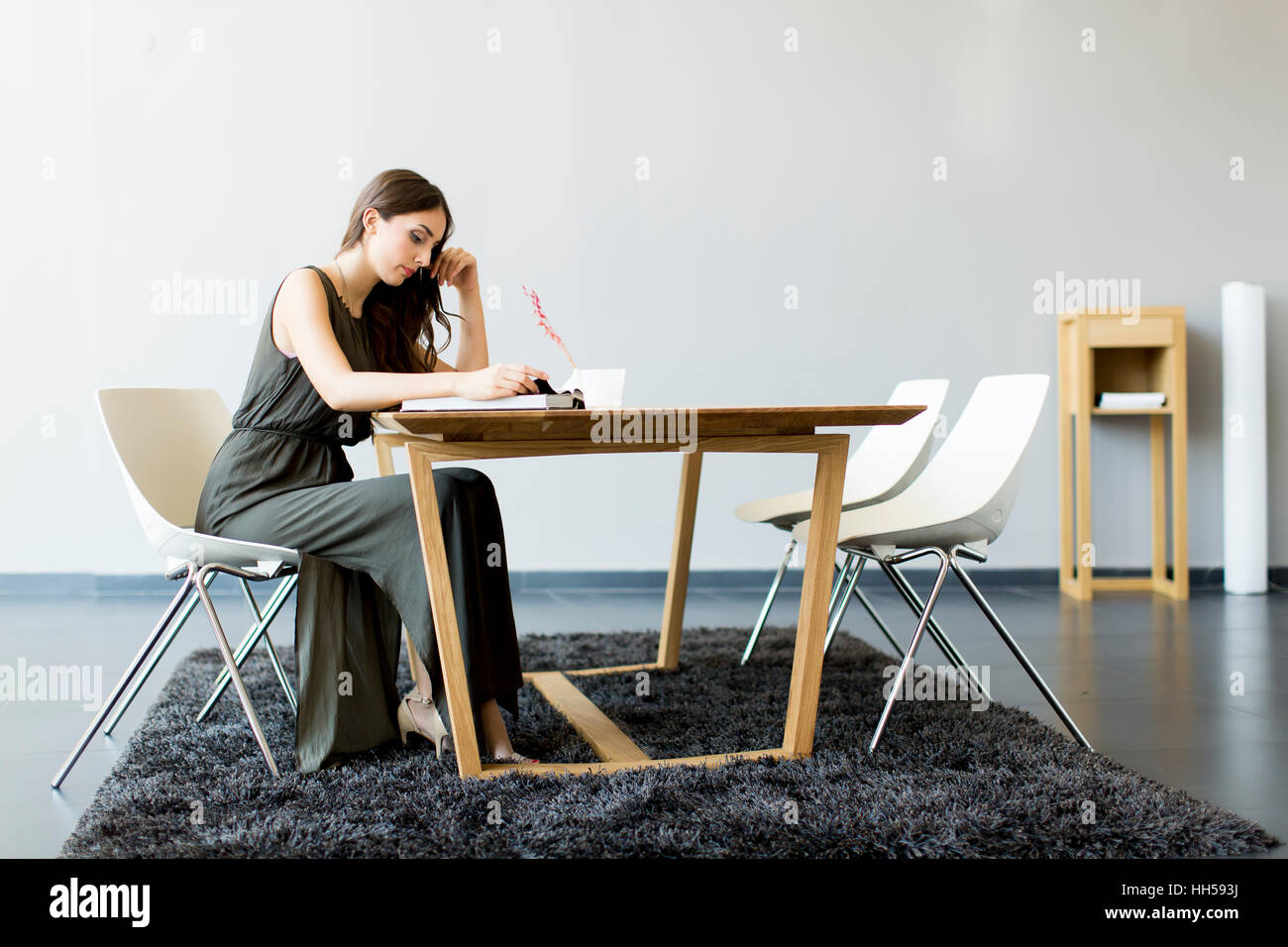 Woman reading sitting table hi-res stock photography and images - Alamy