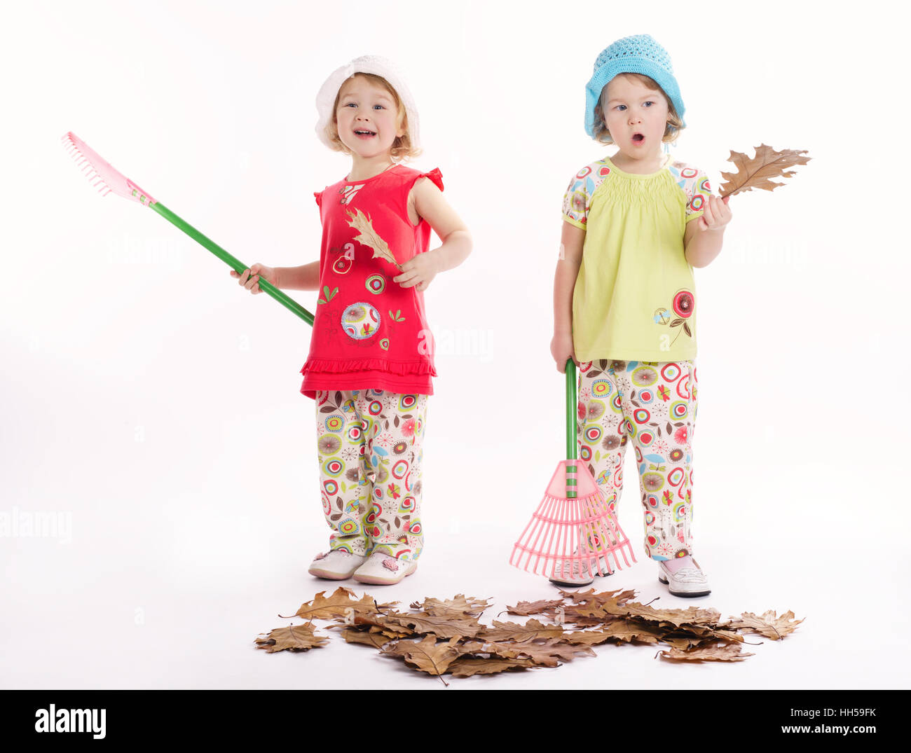 two funny twins raking autumn leaves Stock Photo - Alamy