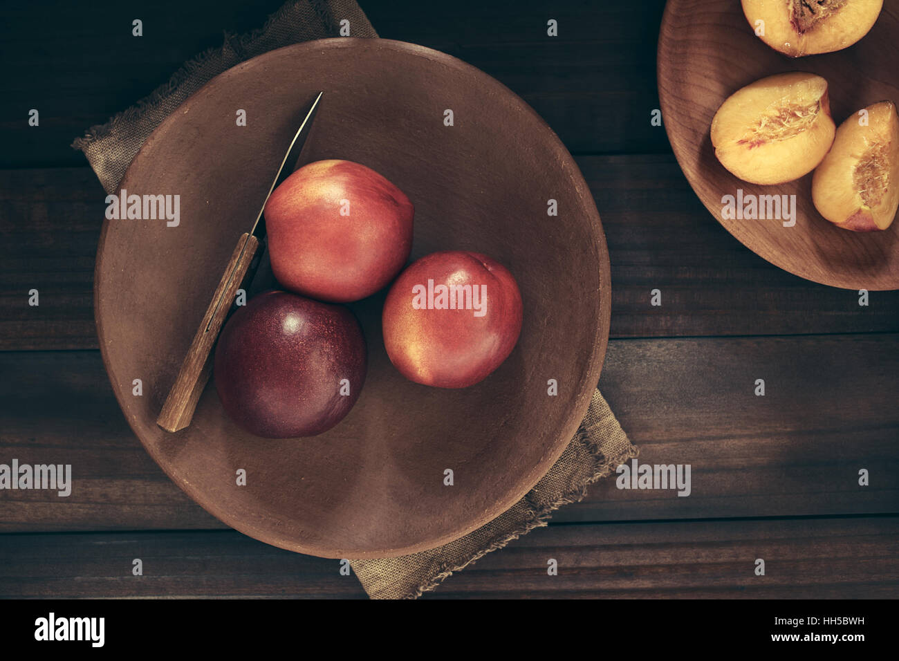 Fresh ripe nectarine fruits with knife on rustic plate with nectarine ...