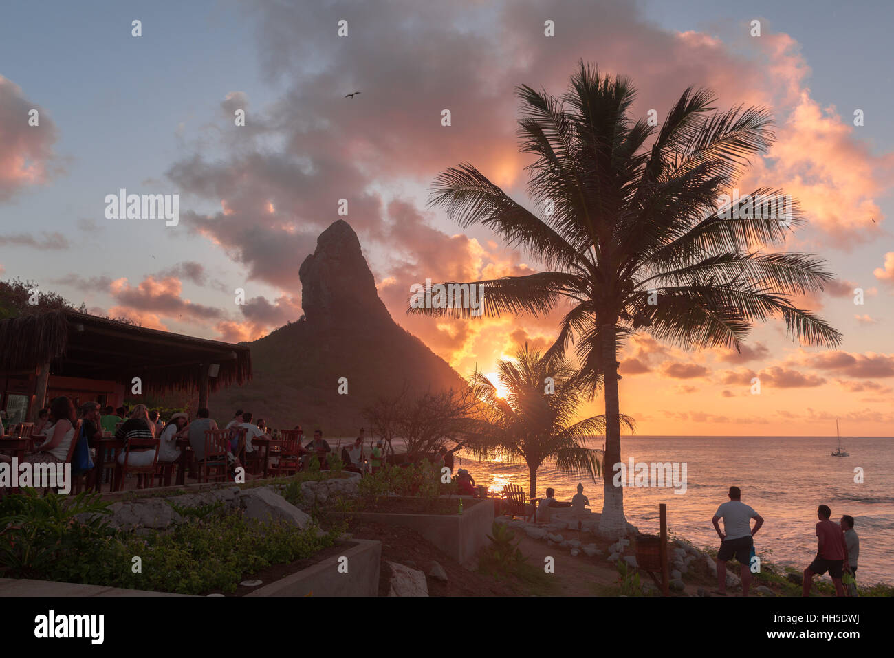 Watching the sunset behind the rock "Morro do Pico", island "Fernando ...