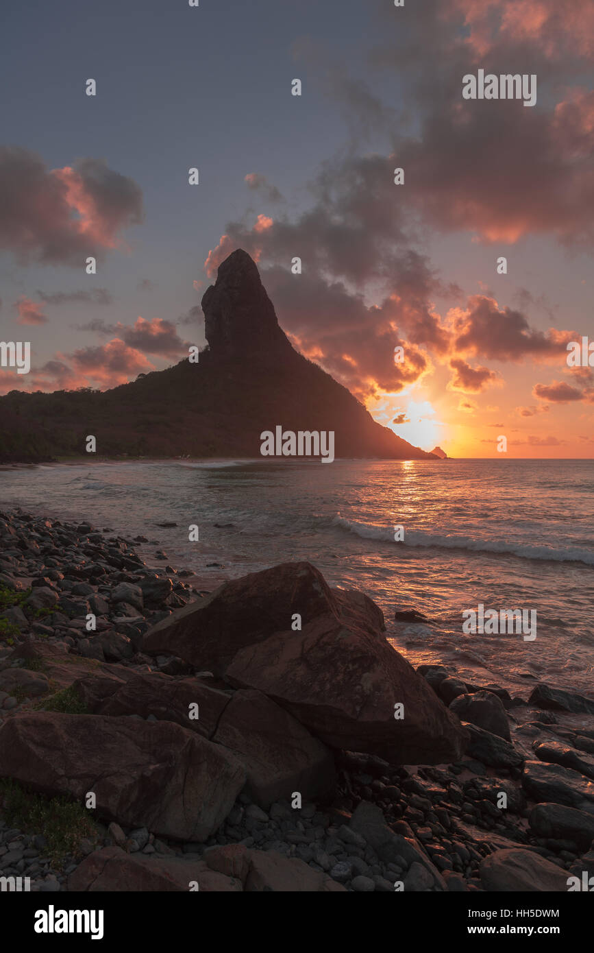 Spectacular sunset behind the rock "Morro do Pico", island "Fernando de ...