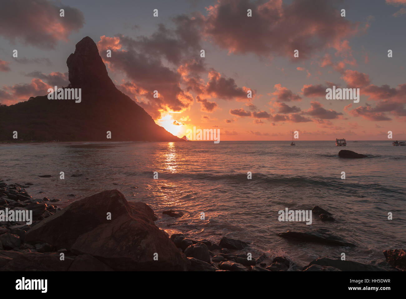 Spectacular sunset behind the rock "Morro do Pico", island "Fernando de ...
