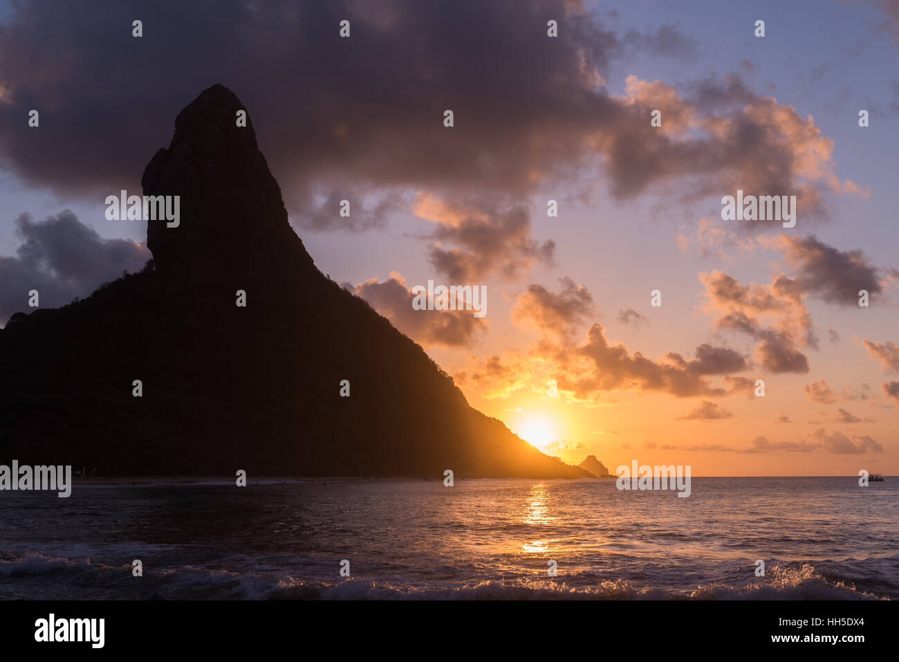 Spectacular sunset behind the rock "Morro do Pico", island "Fernando de ...