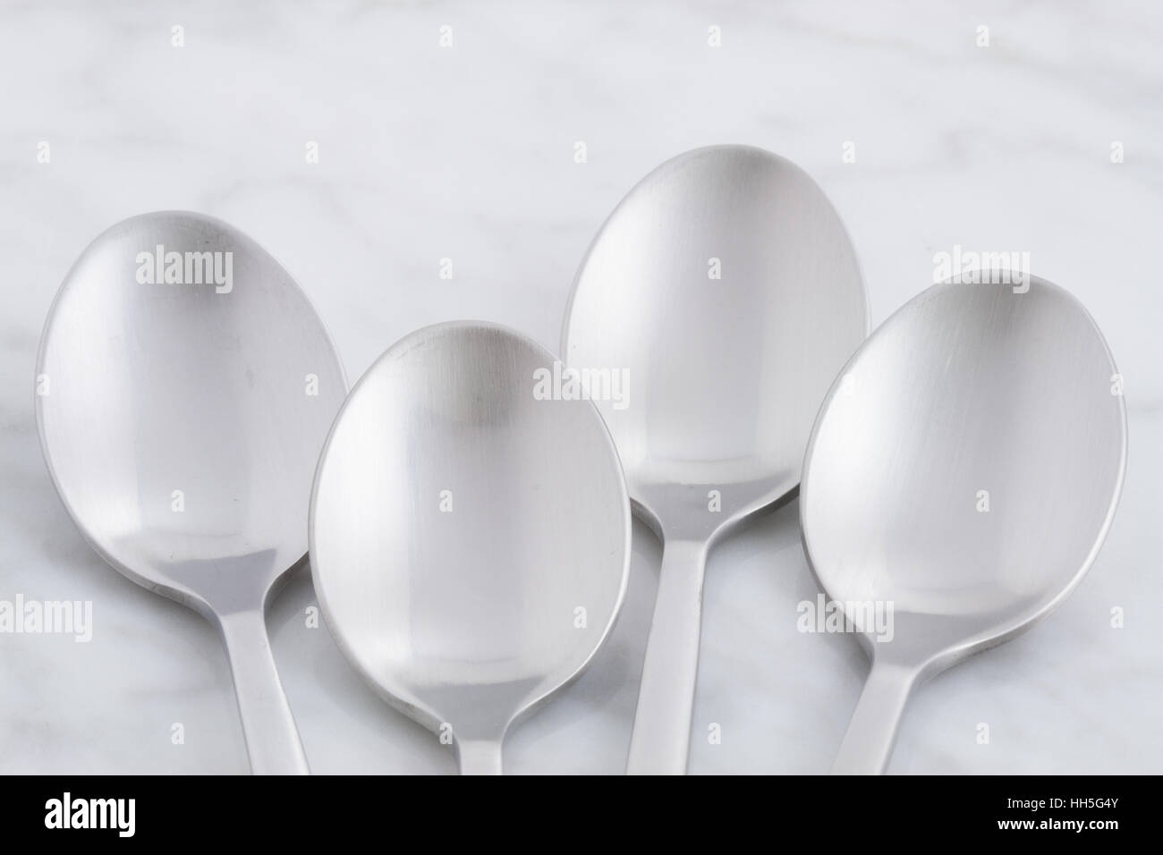silver spoon set styled on antique carrara marble Stock Photo - Alamy