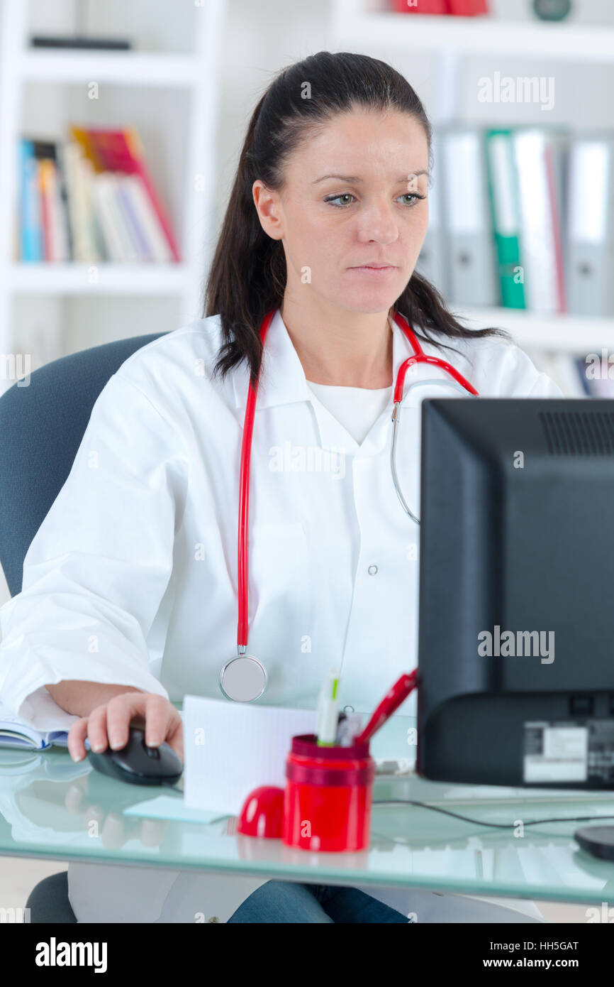portrait of young female doctor sitting at desk in hospital Stock Photo ...