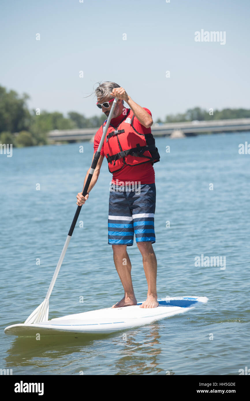 man enjoying a ride on the lake with paddleboard Stock Photo - Alamy