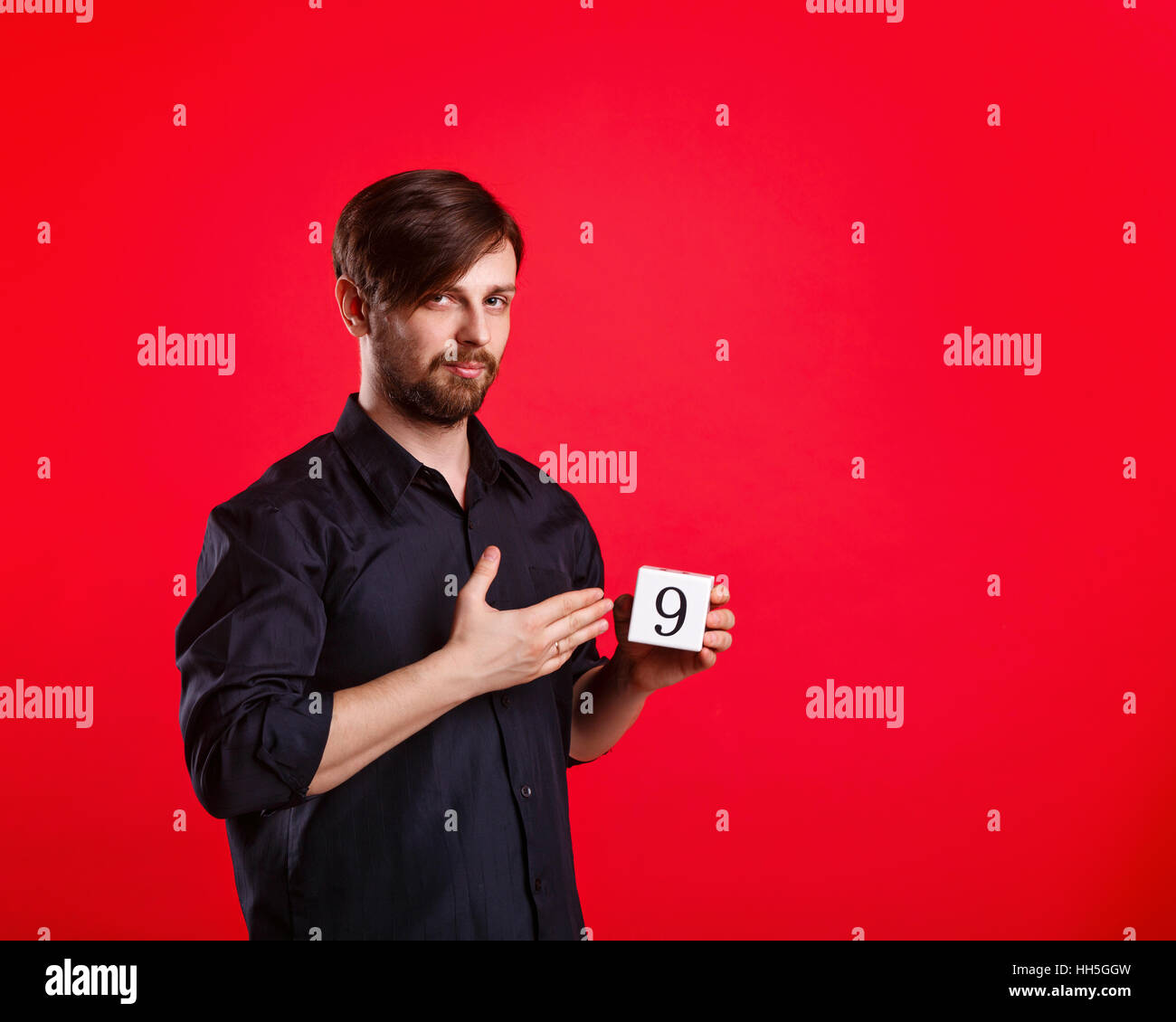 Man holding a cube with the number nine. Numerals. A man shows a cube ...