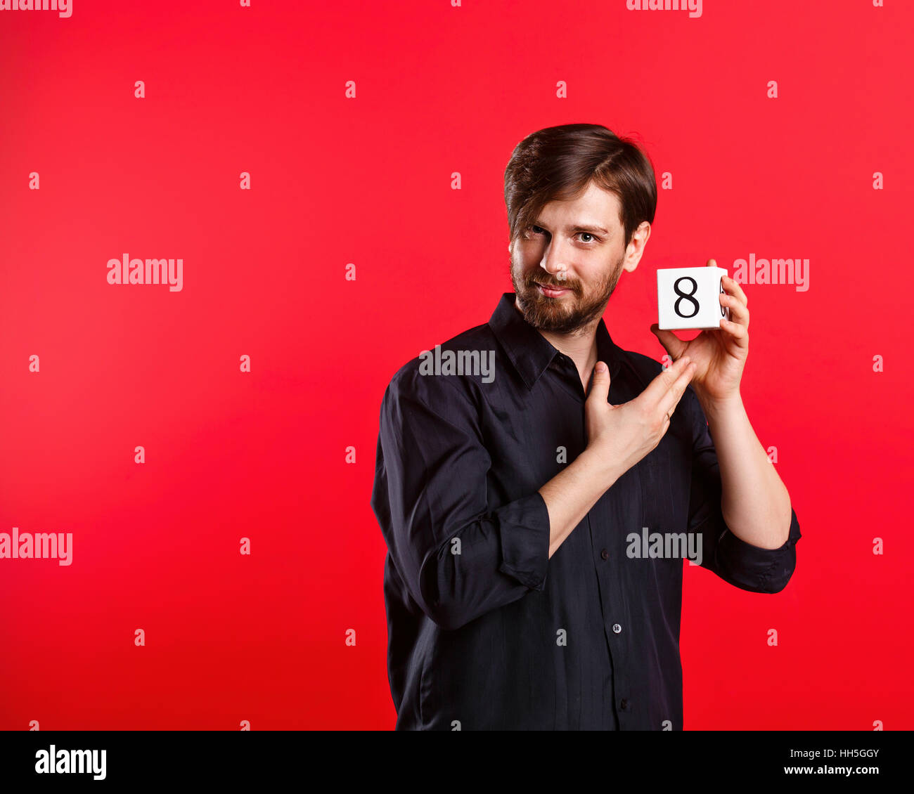 Man holding a cube with the number eight. Numerals. A man shows a cube ...