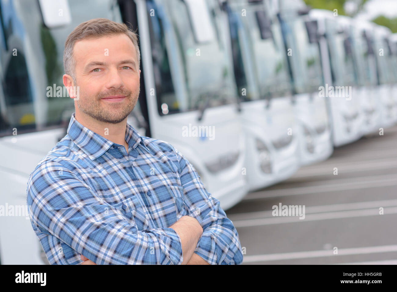 Portrait of man with fleet of buses Stock Photo - Alamy