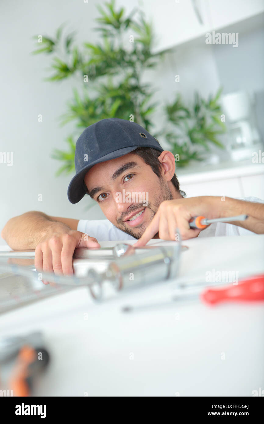portrait of plumber installing sink in kitchen Stock Photo - Alamy