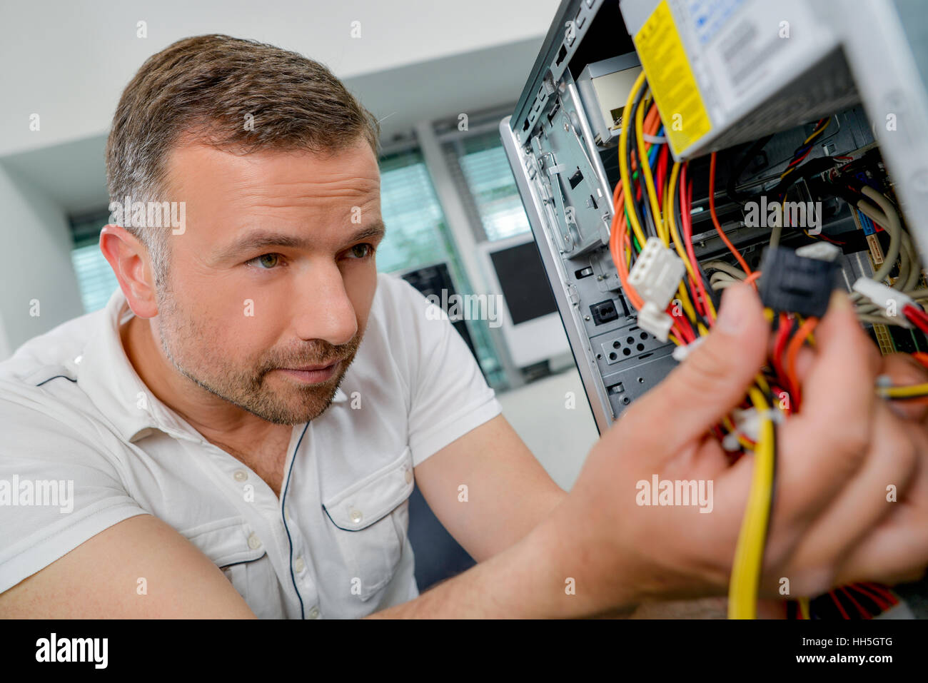 Trying to fix his computer Stock Photo - Alamy