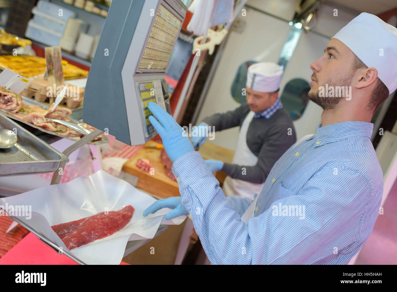 Butcher weighing meat Stock Photo - Alamy