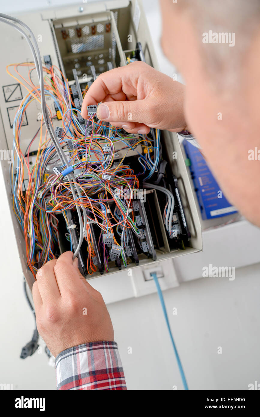 Man holding cables in electrical box Stock Photo - Alamy