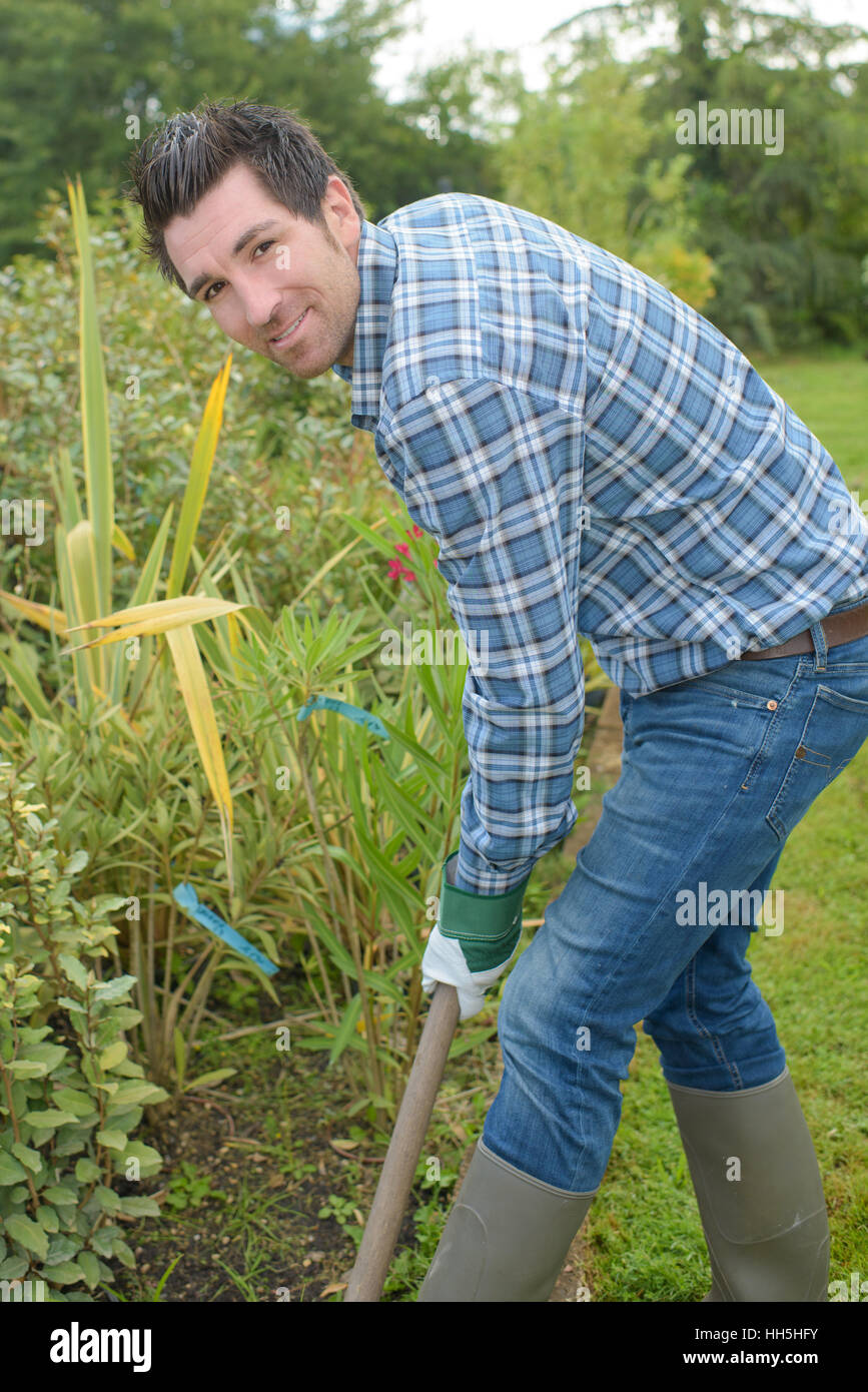 Gardener digging flower bed Stock Photo - Alamy