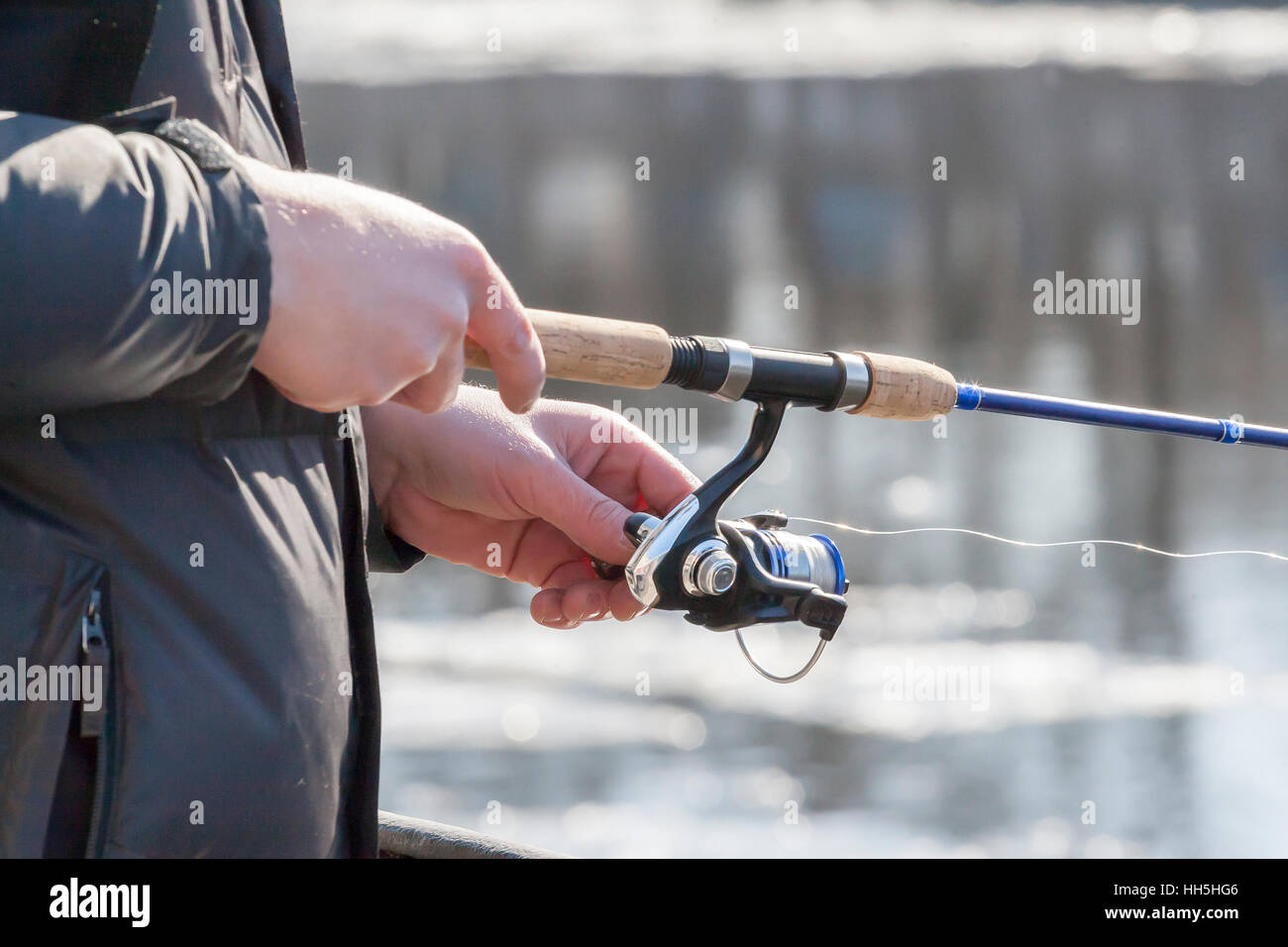 man hand with fishing rod and reel Stock Photo - Alamy