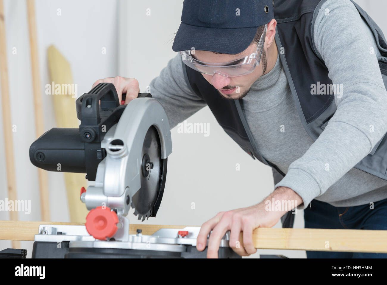 young carpenter using circular saw for wood inside warehouse Stock ...