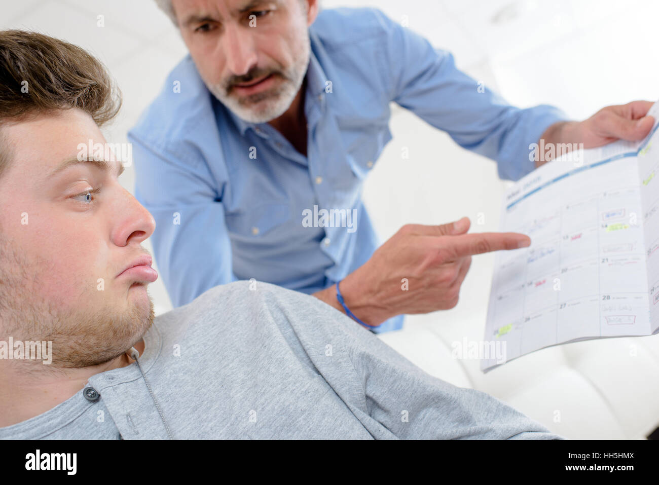 Man pointing angrily at book, young man feigning ignorance Stock Photo ...