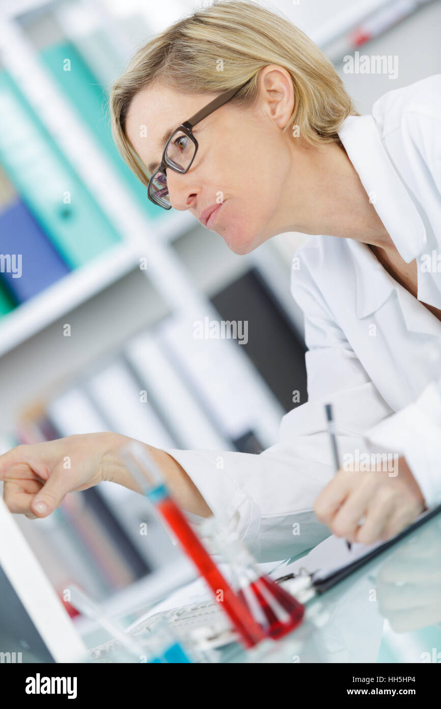 beautiful female lab worker holding up test tube Stock Photo - Alamy