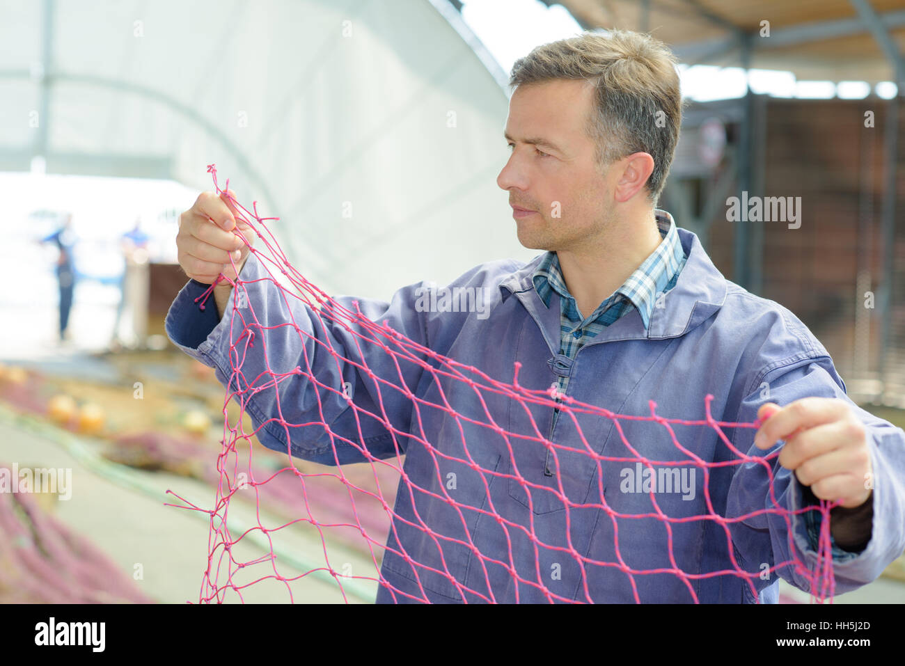 Fisherman holding up net Stock Photo - Alamy