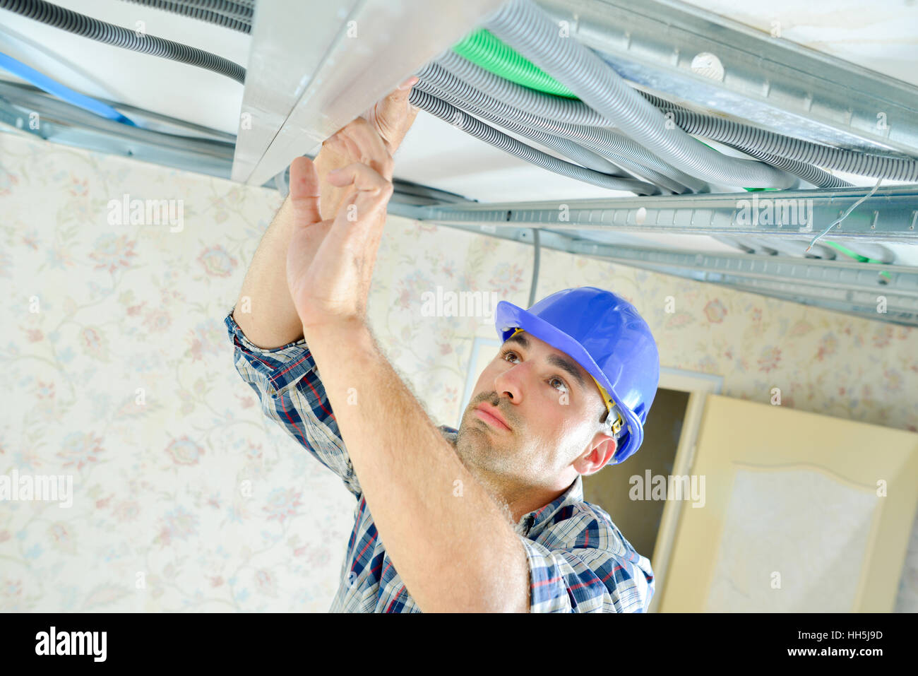 Worker routing cables Stock Photo - Alamy