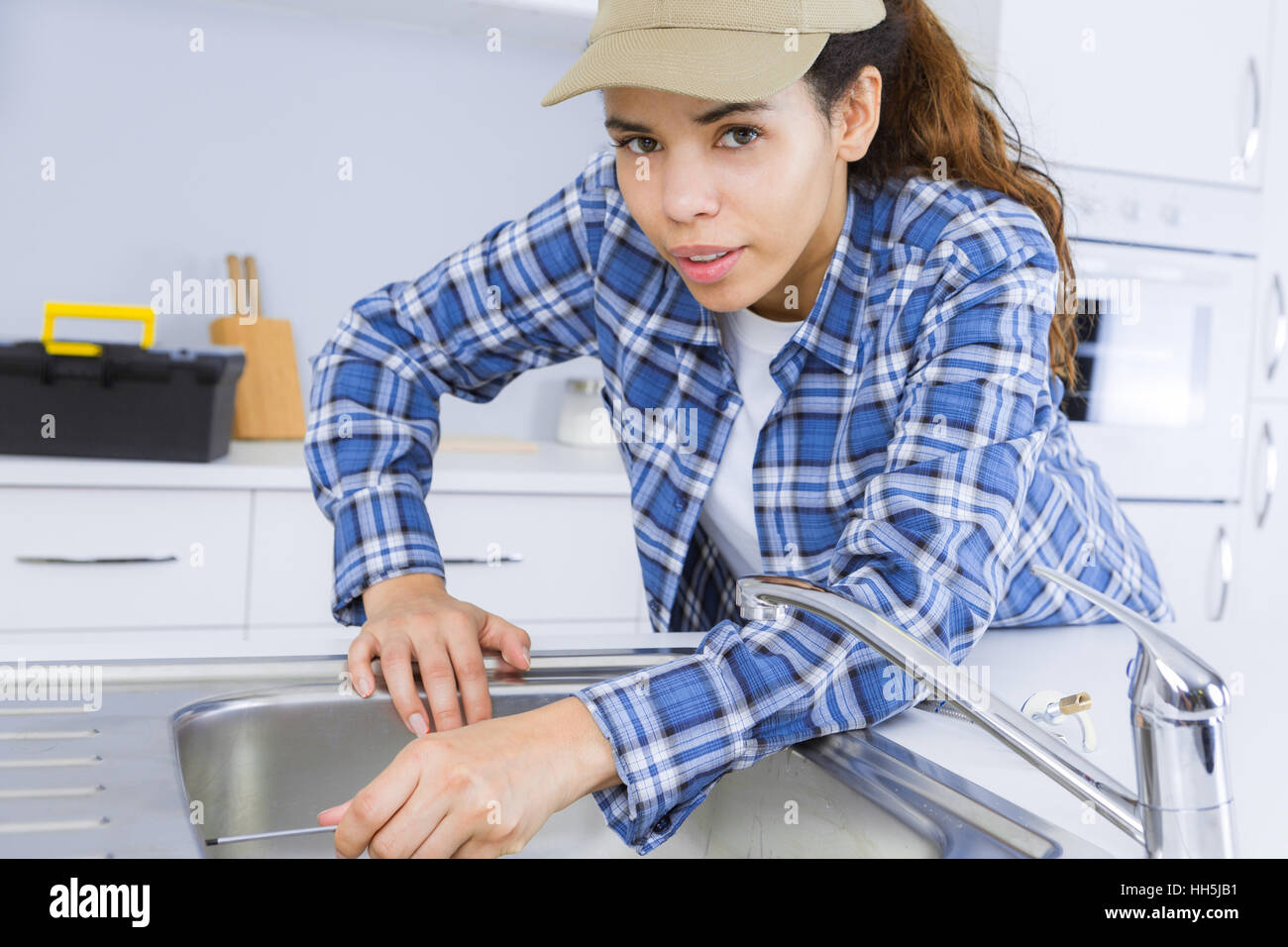 female plumber fixing a sink Stock Photo - Alamy