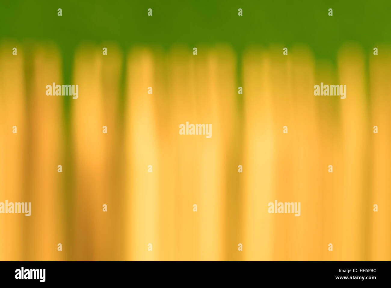 Abstract upright yellow fringe against green background Stock Photo - Alamy