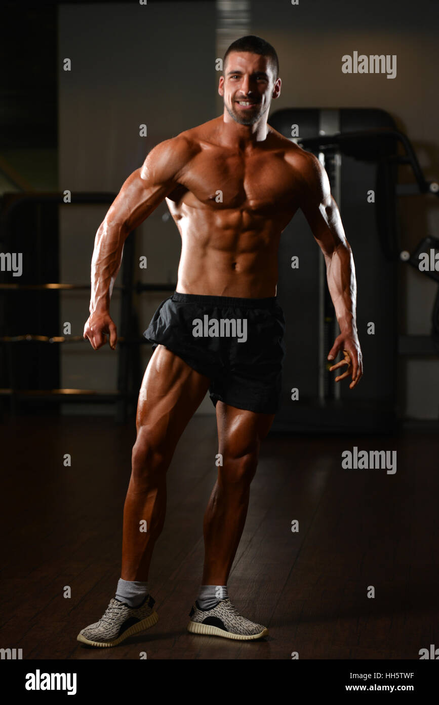 Healthy Man Standing Strong In The Gym And Flexing Muscles - Muscular ...