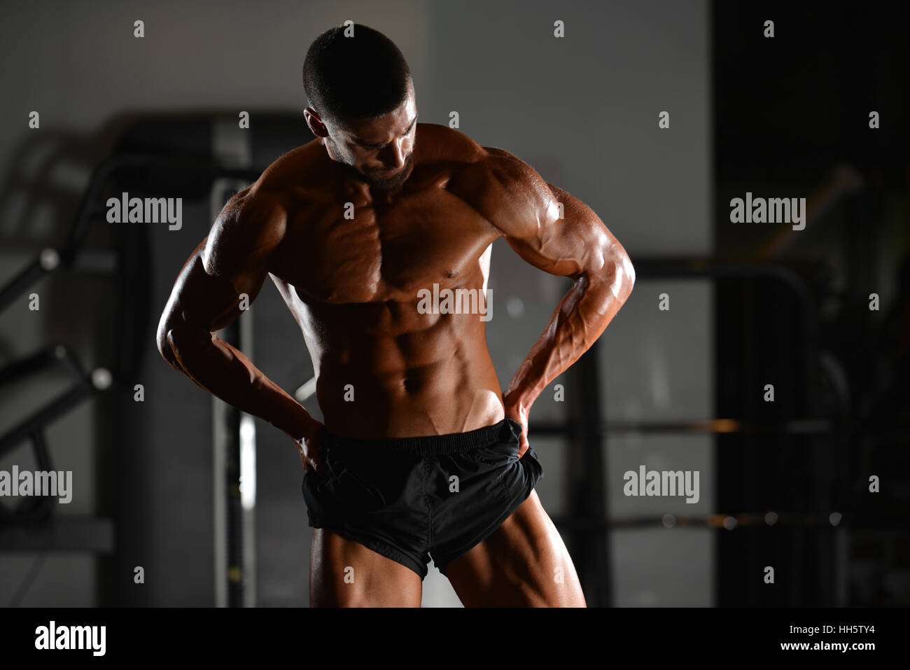 Handsome Young Man Standing Strong In The Gym And Flexing Muscles ...