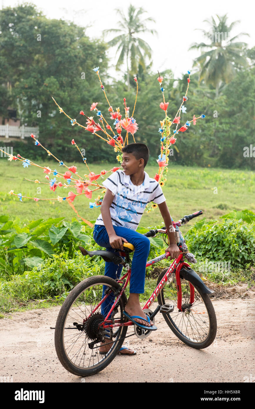 Boy riding decorated bike in procession, Il Full moon Poya festival ...