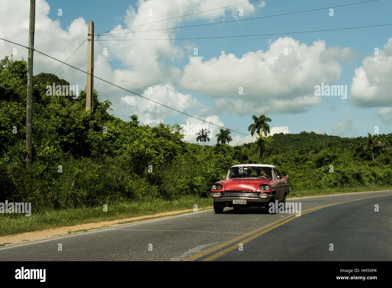 A classic car passes by on the road towards Viñales, Cuba Stock Photo ...
