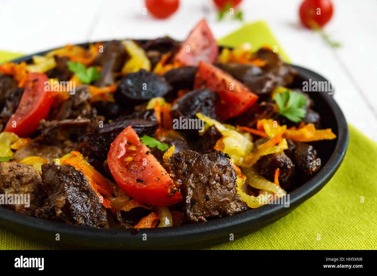 Pieces of roast duck, goose (meat, liver, heart) with vegetables (onion ...